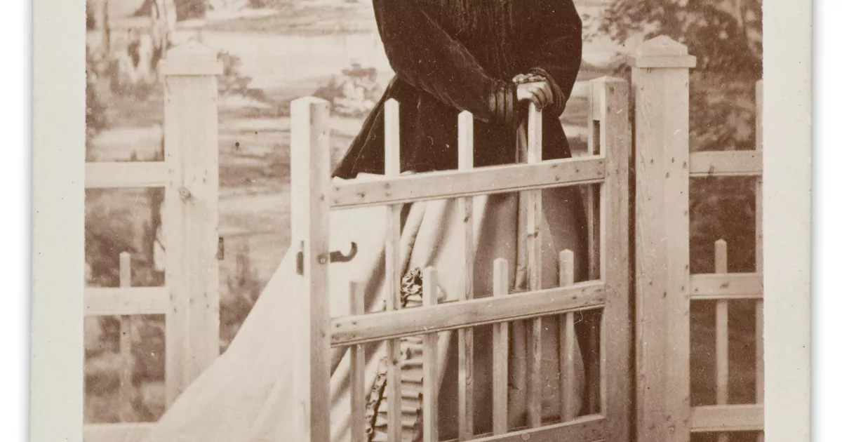 Portrait of woman posed against gate - AGSA Collection