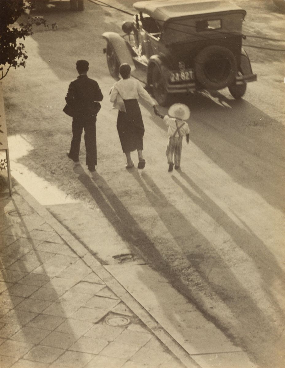 Family walking on street, long shadows - AGSA Collection