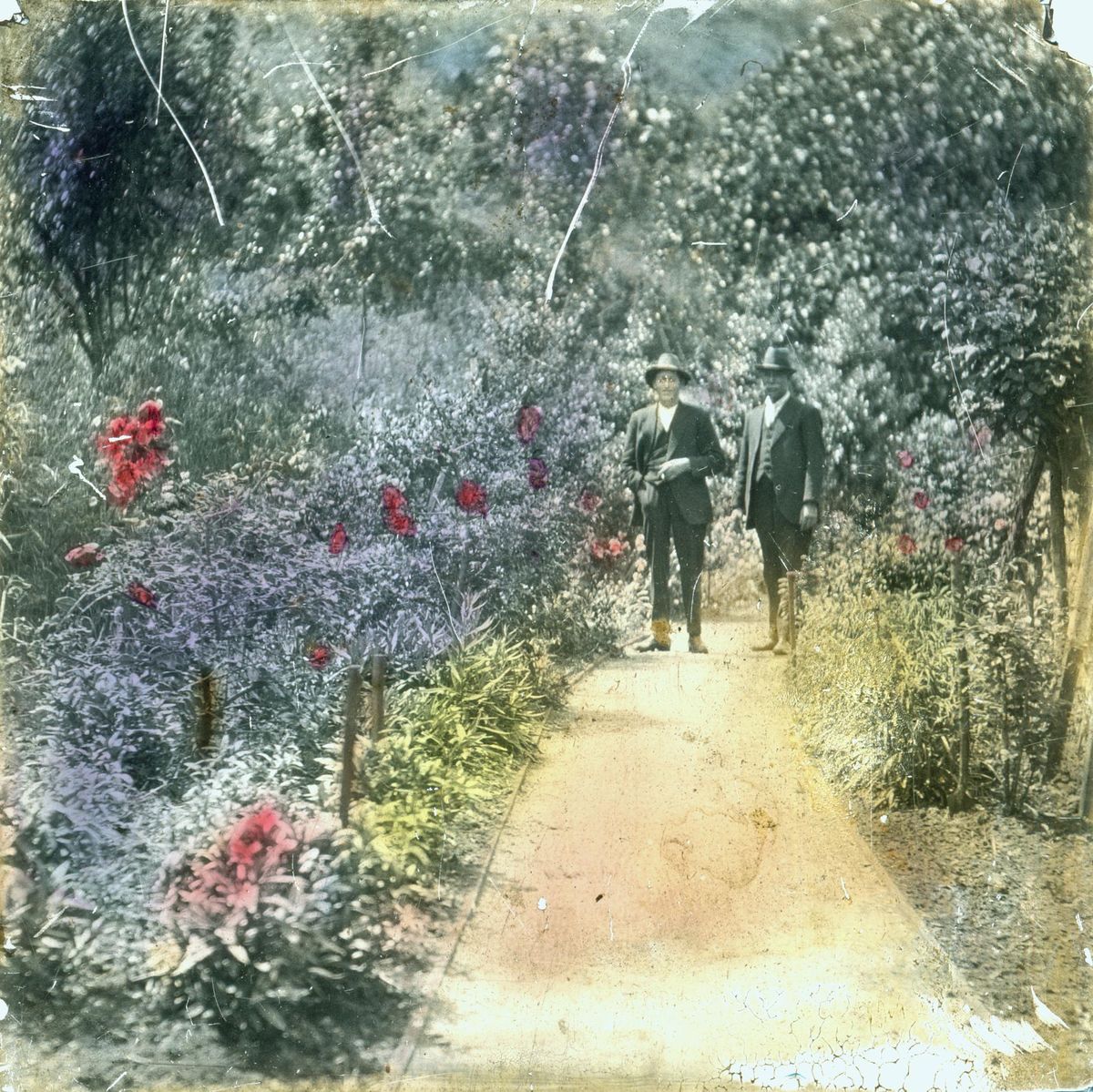 Two men walking on garden path - AGSA Collection