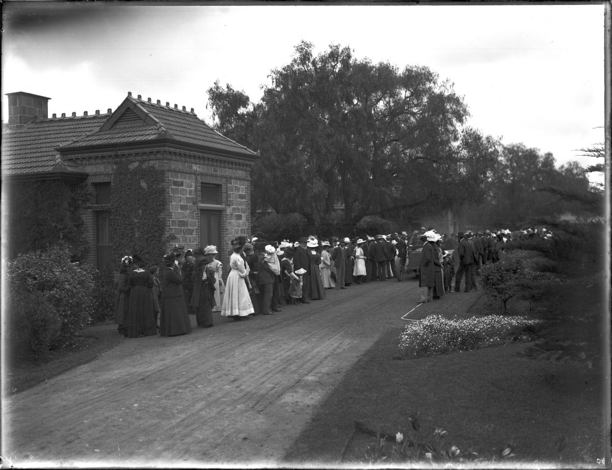 Group gathered along unsealed road, stone structure at left - AGSA ...